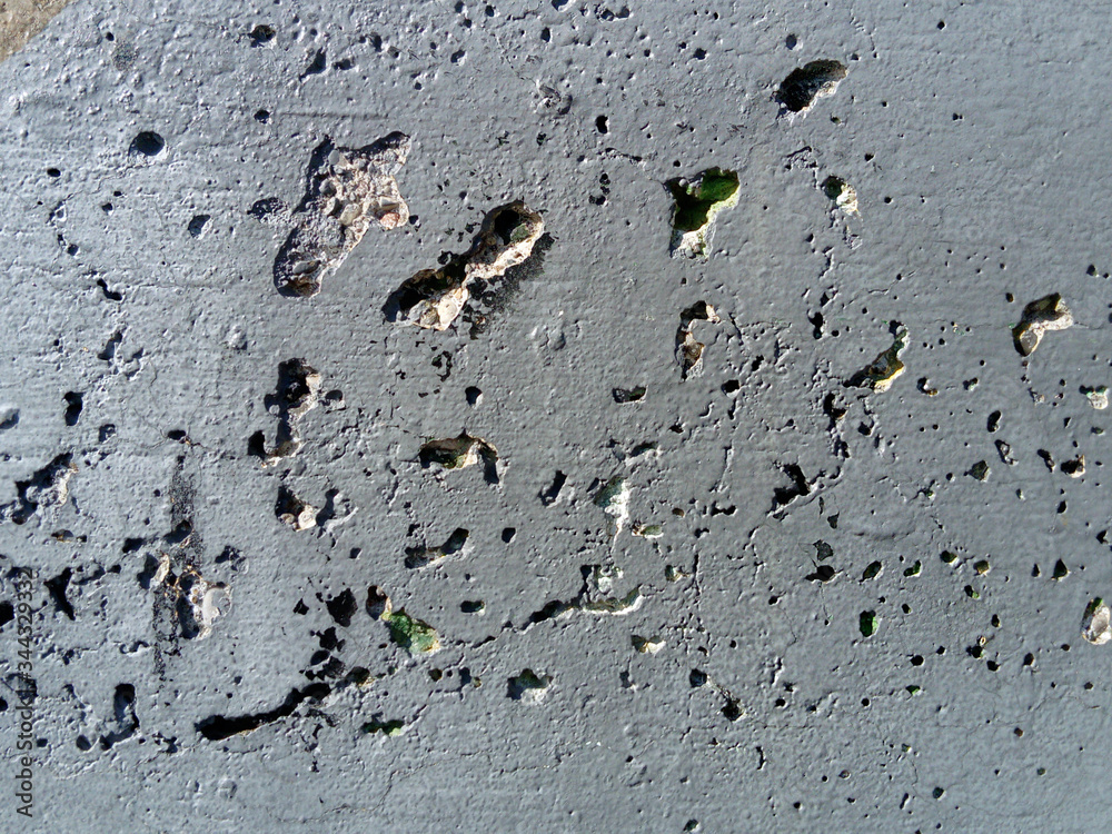 Concrete wall with concentric damage of large radius. Potholes ...