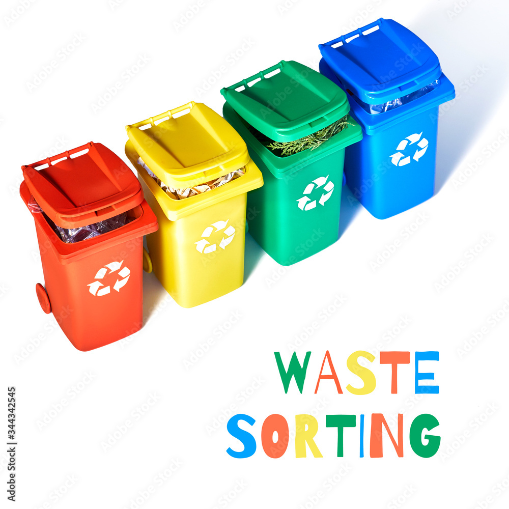 Four color coded recycle bins. Recycling sign on the bins - red, blue ...