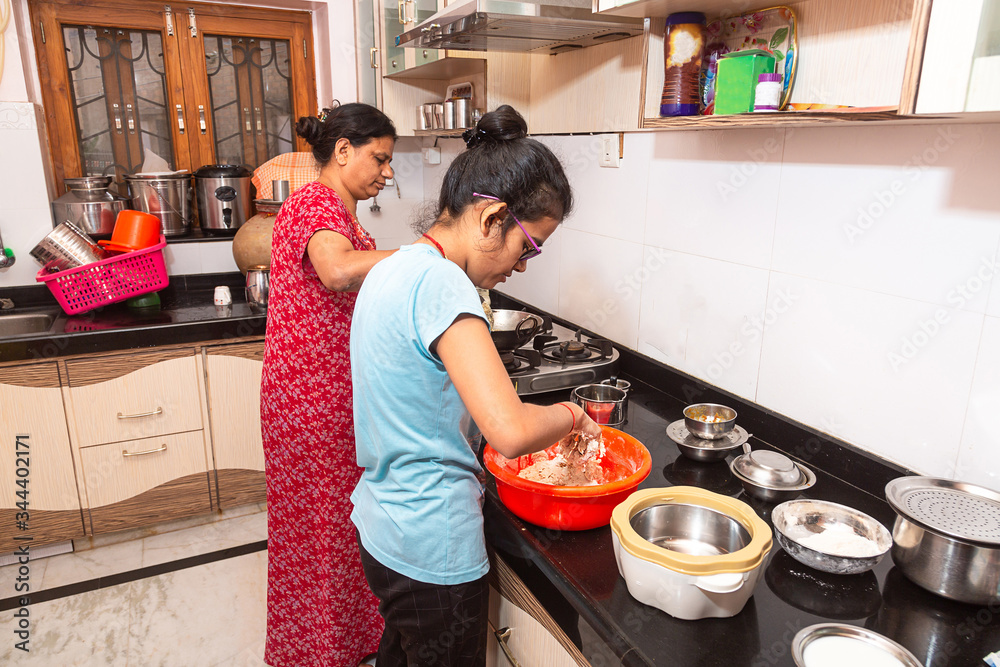 Indian Mother and Daughter Cooking kitchen together. Household activity ...