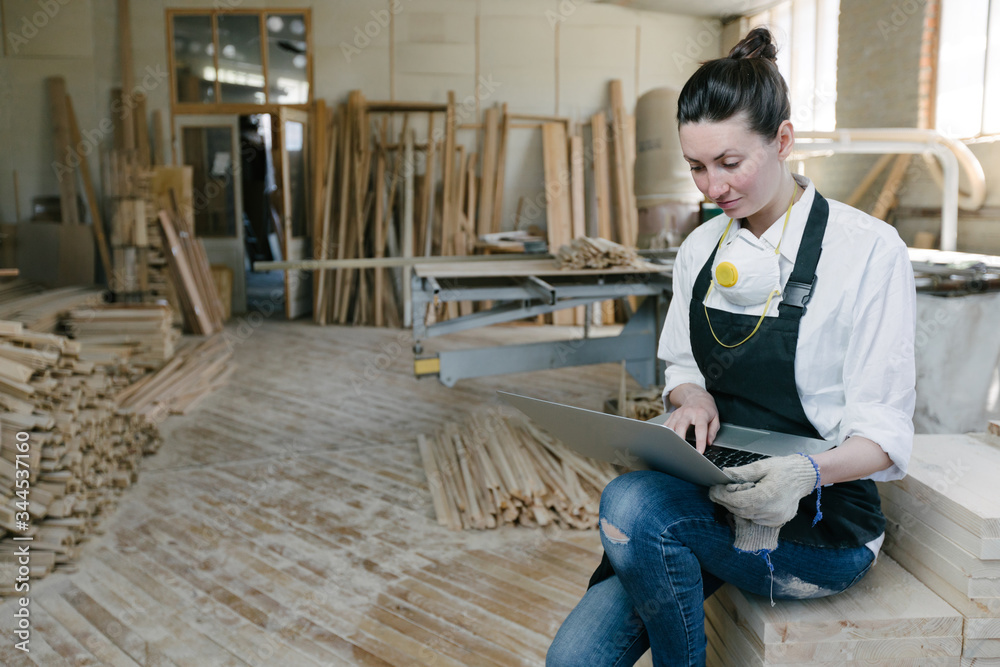 Confident woman working as carpenter in her own woodshop. She using a ...