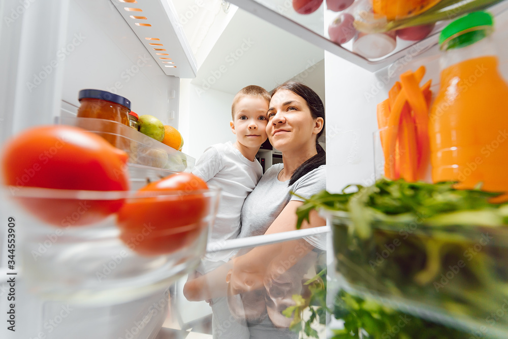 Mother with her baby opening refrigerator at kitchen Stock Photo ...