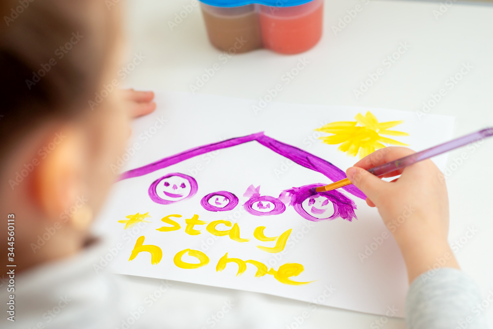 Child is drawing family under a roof with words Stay Home on sheet of ...
