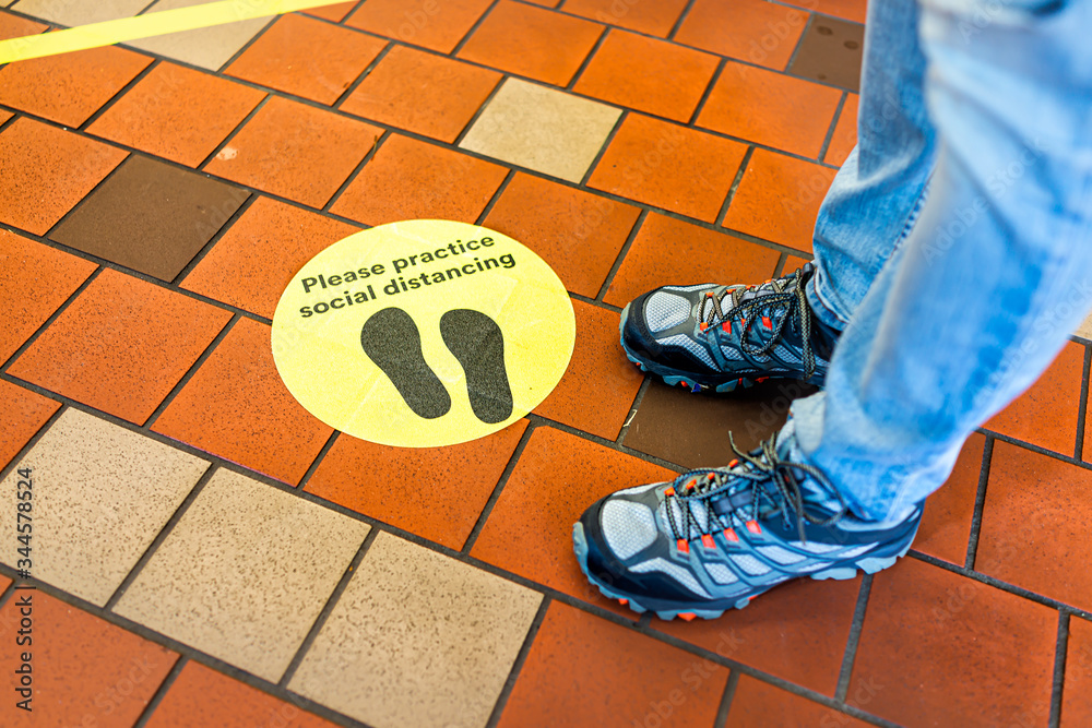 Yellow warning sign to maintain social distance distancing during covid ...