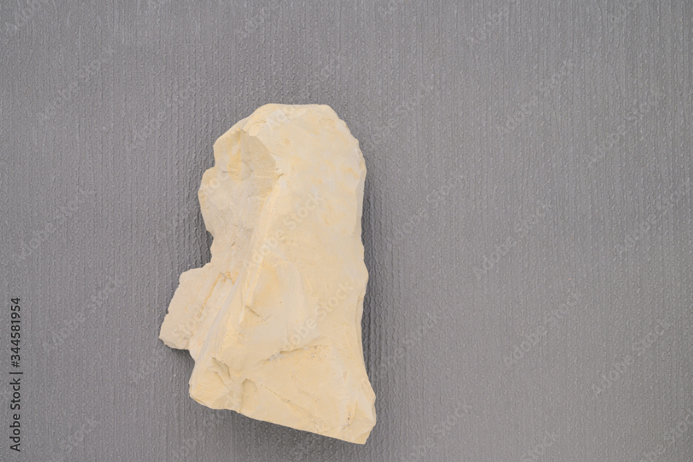 Shattered white clay on the grey background. Close up. Ural food clay ...