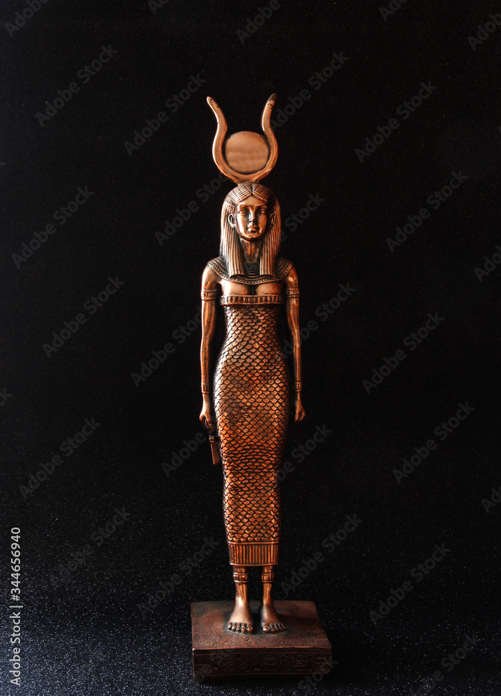 The Egyptian goddess ISIS on a black background. A bronze Egyptian ...