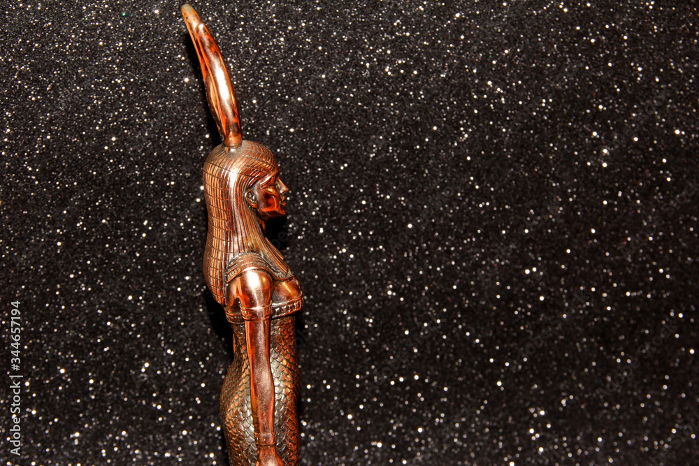 The Egyptian goddess ISIS on a black background. A bronze Egyptian ...