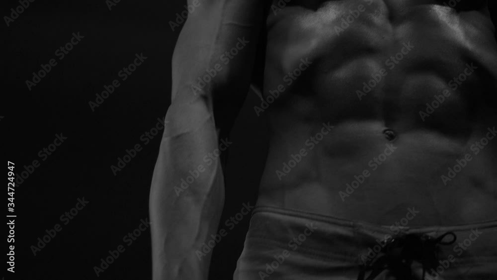 Strong bodybuilder posing and training in contrast light showing his ...
