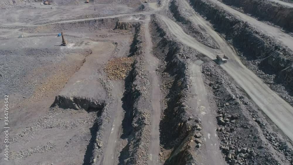Mining dump trucks in large granite open pit mine. Empty truck rides on ...