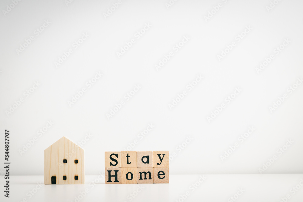 "Stay home" message on wooden dices and home wooden model. Stay home ...