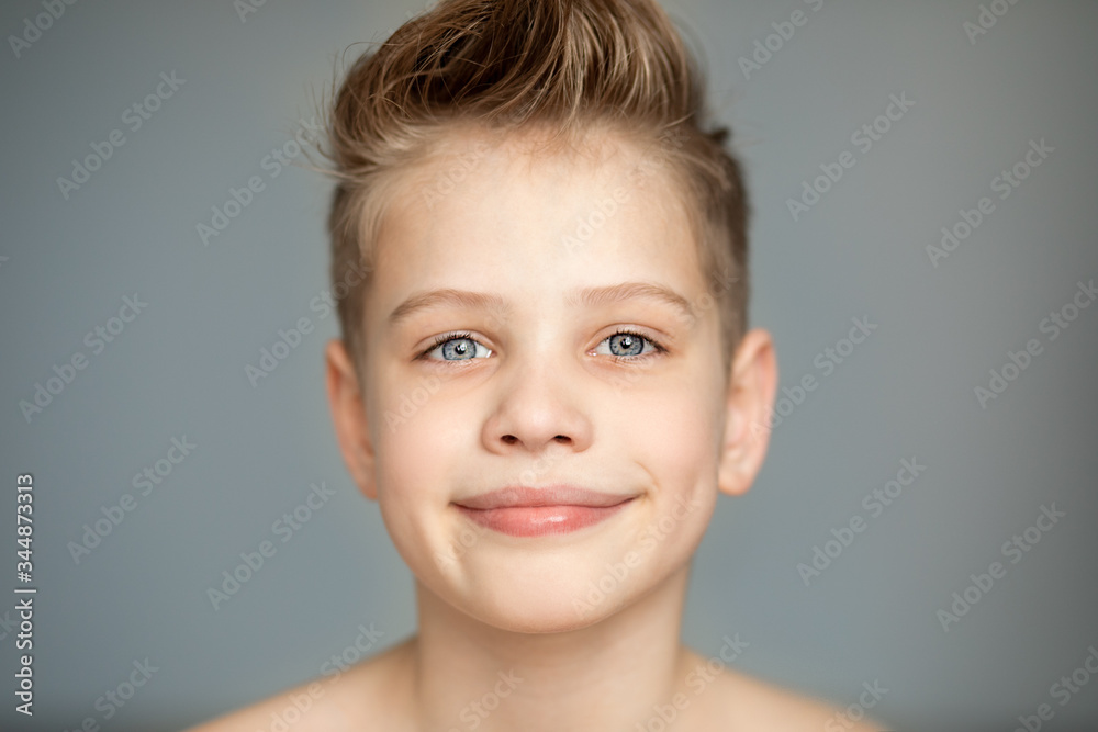 cute boy emotionally stretches his lips into a smile. A freestanding ...