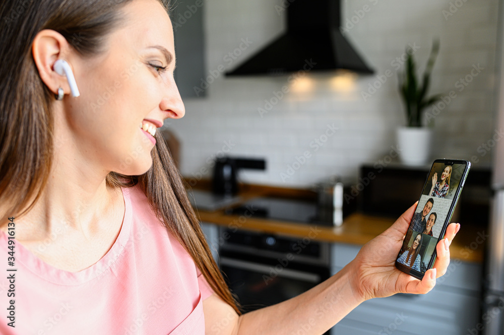 A young happy woman using zoom app on a smartphone for meeting with ...