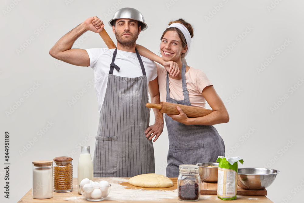 Time to cook. Friendly cook team make dough, hold wooden rolling pins ...
