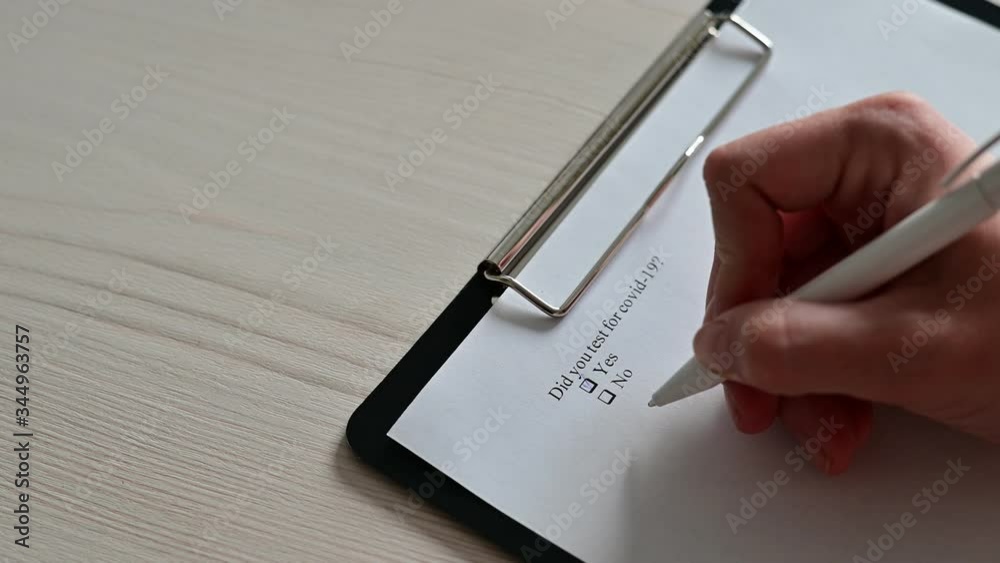 Unrecognizable woman puts a daw in the questionnaire. A close-up of a ...