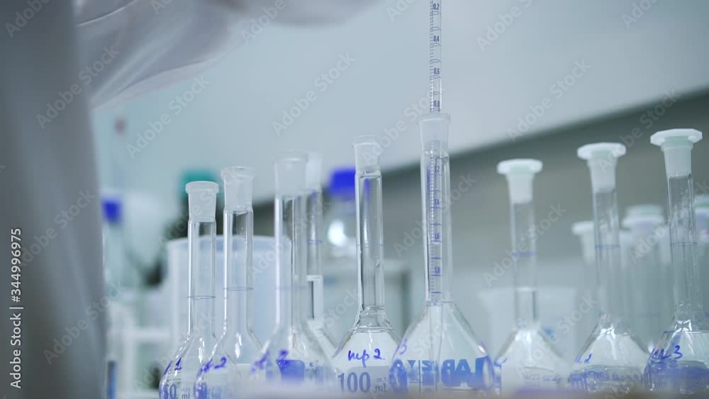 worker chemist dripping liquid into test tube flask Spbd. Closeup ...