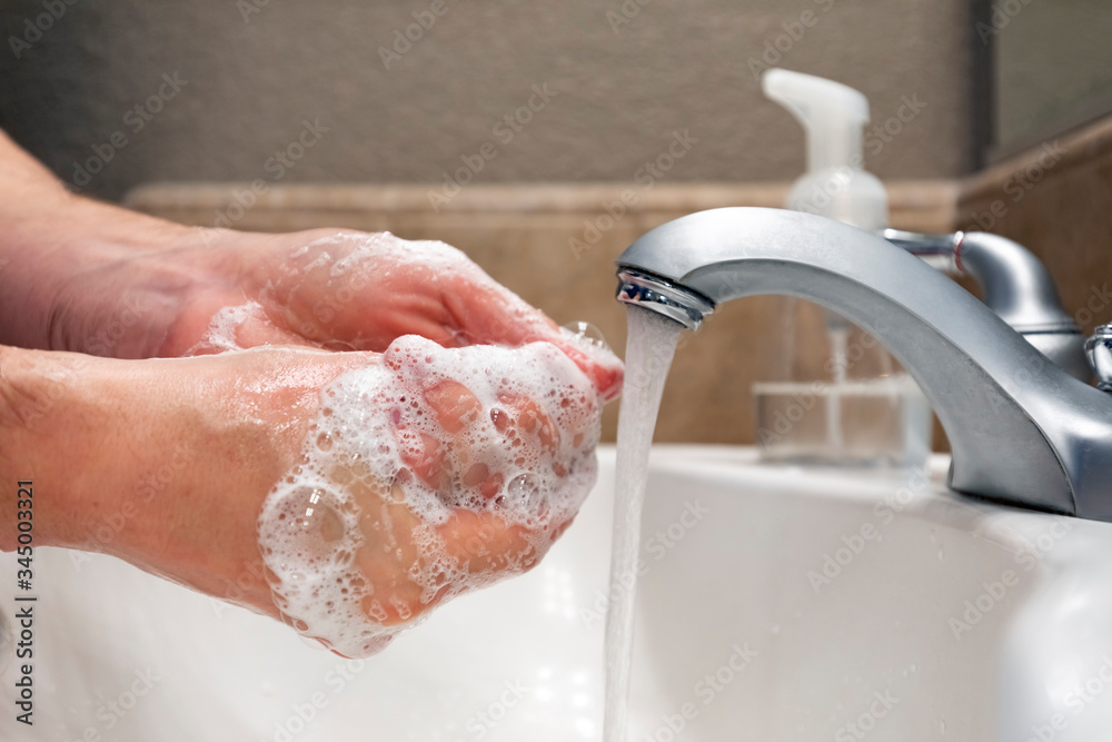 Washing hands with soap and water in bathroom sink, protection against ...