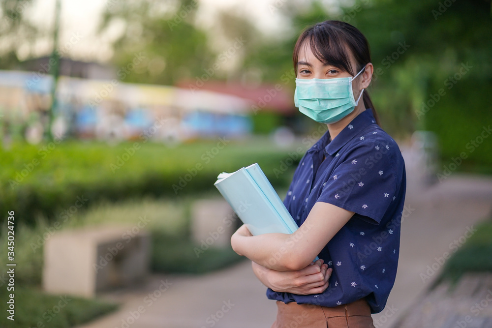 Portrait Young Asian student girl wearing medical mask and holding ...