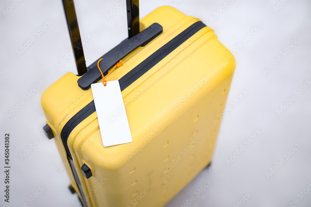 Close up mock up brand tag or name tag tied to yellow thick suitcase ...