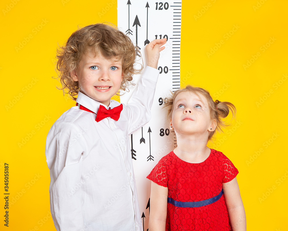 Foto de The older brother measures the height of the younger sister ...