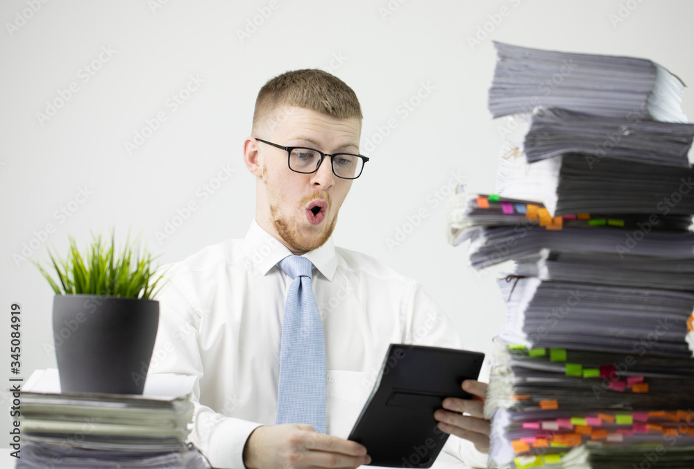 Shocked male office worker in formal clothes and glasses with papers ...