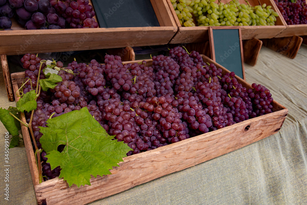 Box of red grapes on a market stall. Picture taken in a food market ...