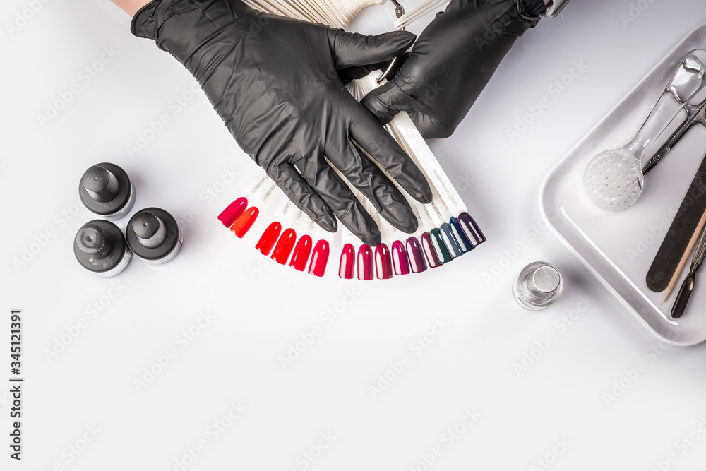 Master woman manicurist chooses color of nail polish from palette with ...