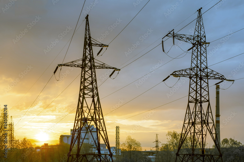High-voltage power lines on plant and sunset background Stock Photo ...