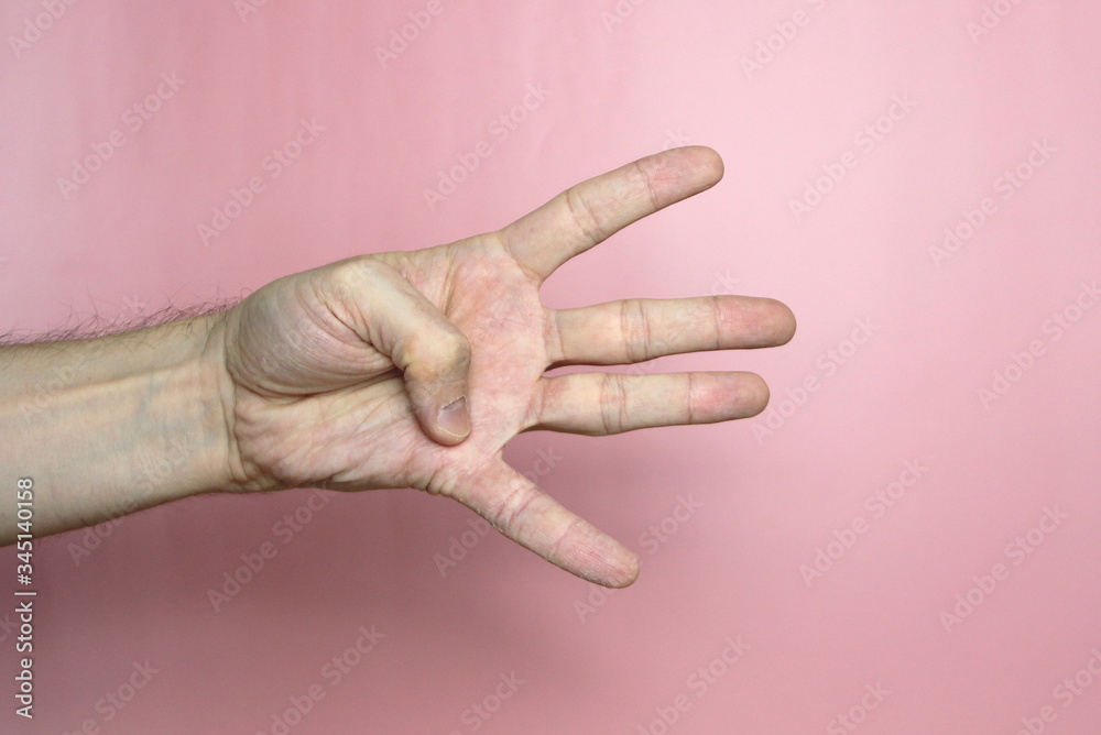 Male hand with fair skin shows a gesture, hand on a light pink ...