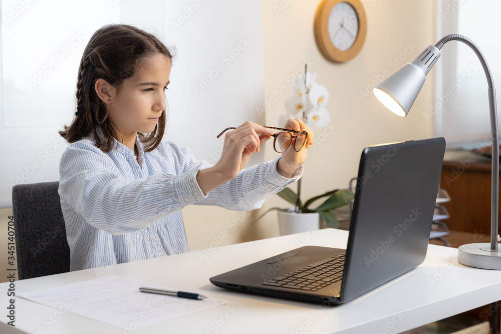 Little girl trying to study with the computer with her glasses Stock ...