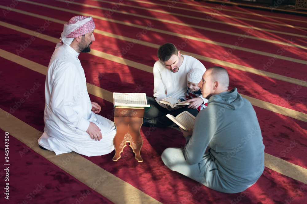 Group of muliethnic religious muslim young people praying and reading ...