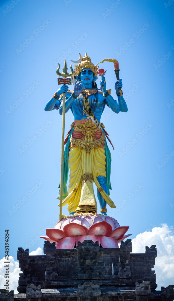 blue shiva, hindu god statue standing up under a bright blue sky Stock ...