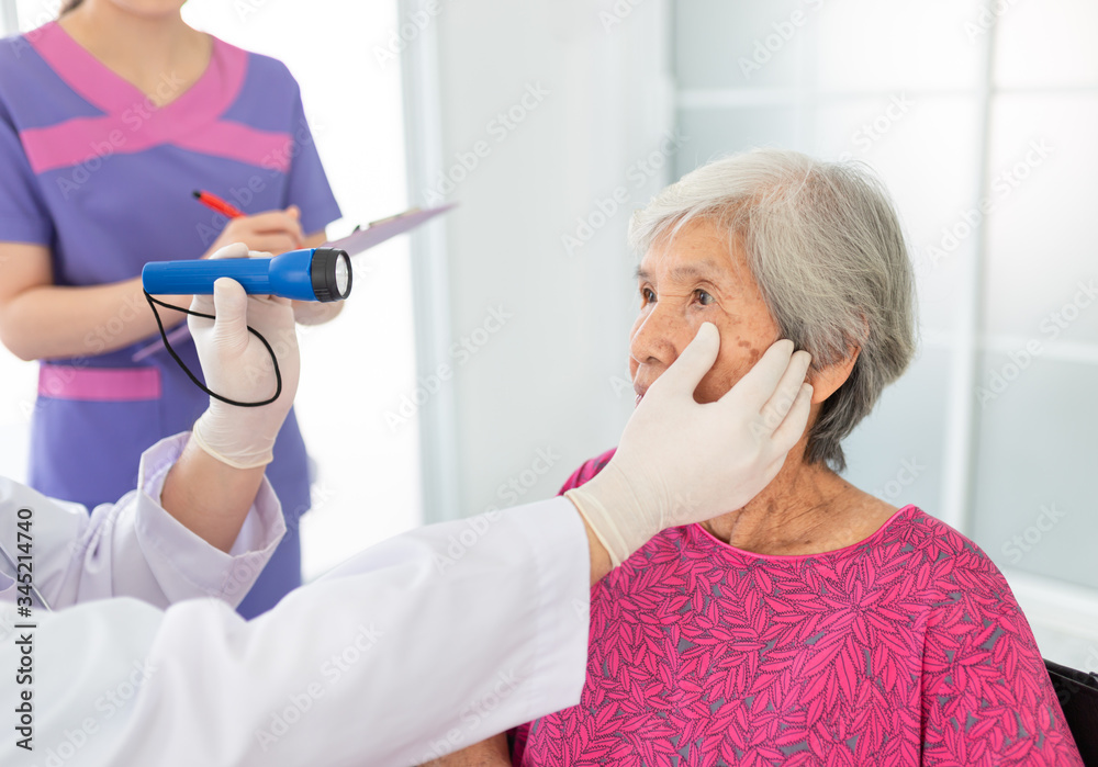 doctor use flashlight screening eyes of old asian patient, vision and ...