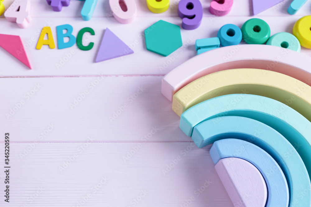 Wooden toy rainbow, numbers, blocks, pastel color arc on pink ...