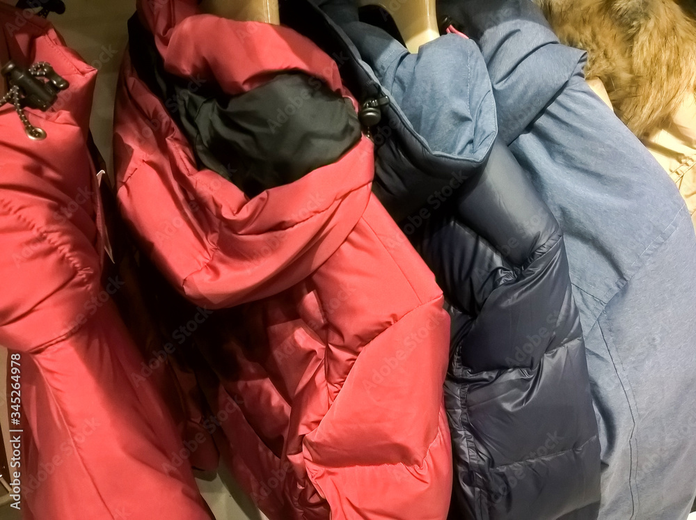 Multi colors of down jackets on the hangers at the store for sell ...