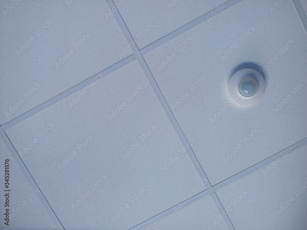 Textured tiles and motion sensor in the t-bar grid of a suspended ...