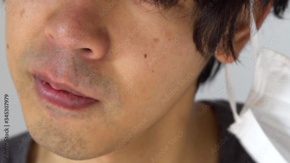 Young asian man taking off face mask. Surgical face masks are used to ...