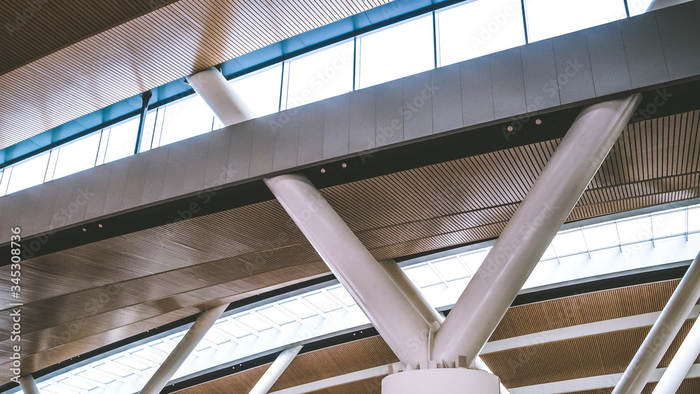 ceiling with wood paneling and windows, large metal columns in a modern ...