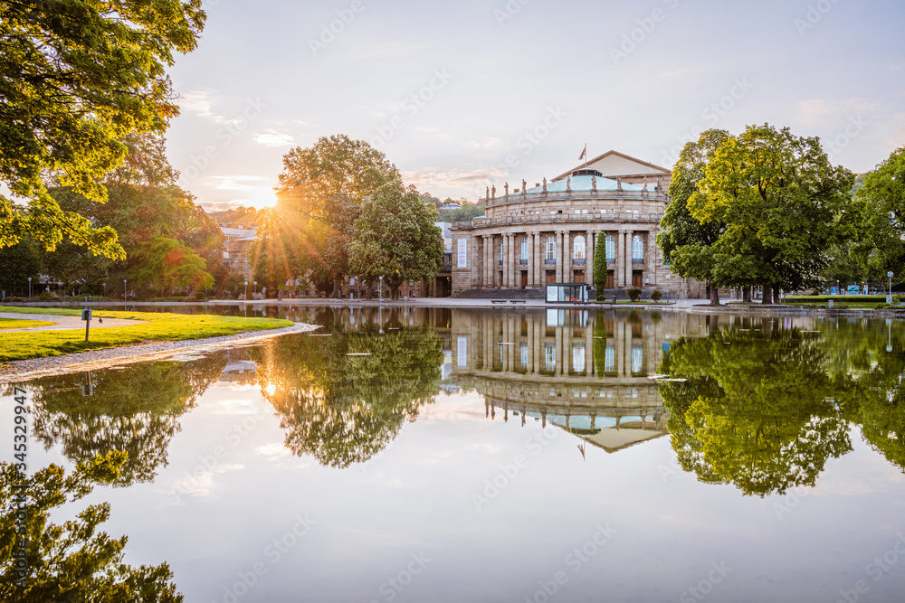 Stuttgart Opera house ("Opernhaus"), reflections of trees in lake, warm ...