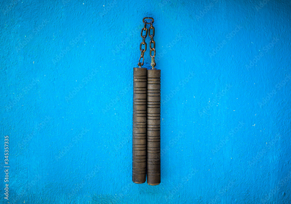 Nunchaku weapon isolated on Blue background. Black nunchaku training ...