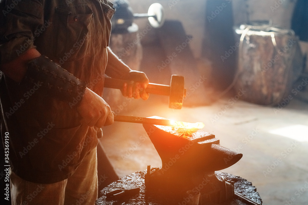 Manual work of a blacksmith in a blacksmith Shop. Hammer blows on the ...