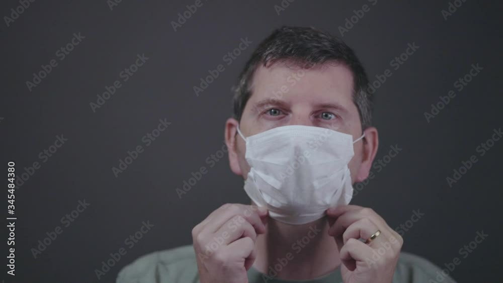 Surgical medical face mask put on by caucasian male with blue eyes ...