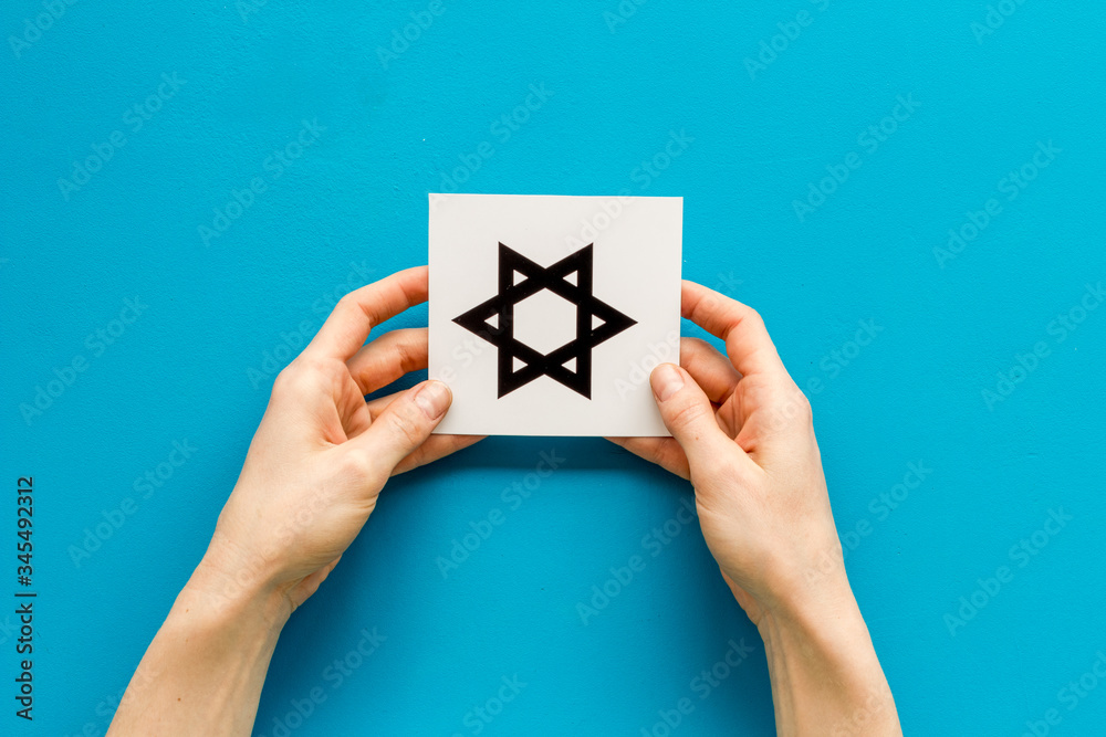 Star of David sign in hands - religion Judaisim symbol - on blue table ...