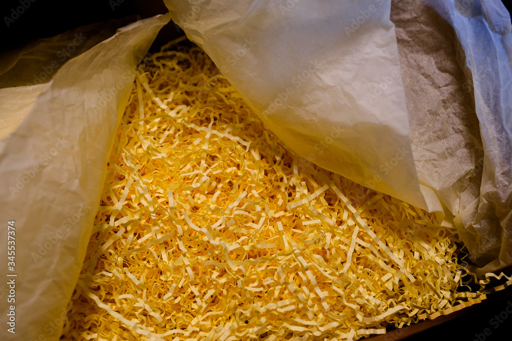 Opened recycled taped cardboard posting and shipping box with shredded ...