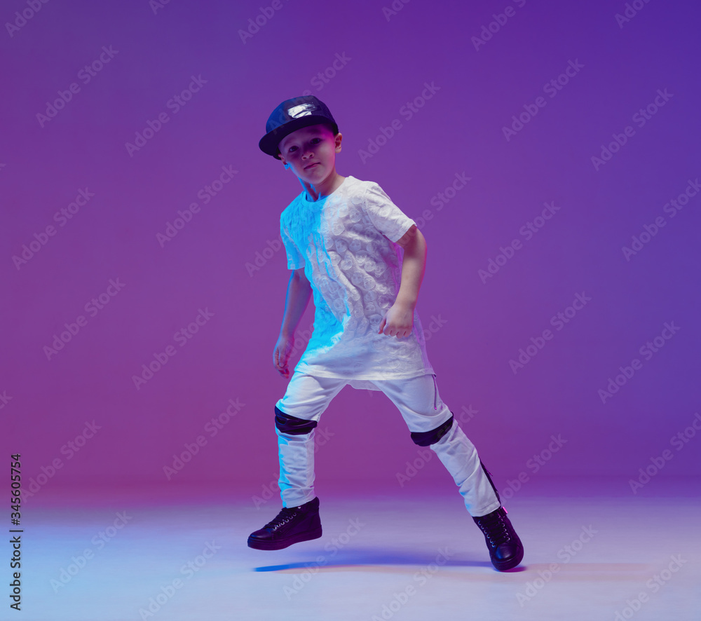 Cool young boy child dancing hip hop in the Studio against the ...