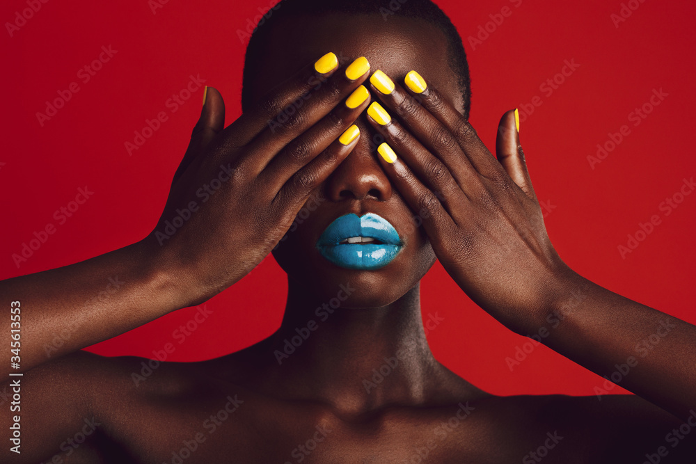 African woman with colorful makeup covering her eyes Stock Photo ...