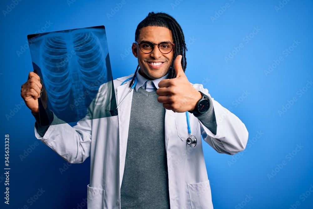 Young african american afro doctor man with dreadlocks holding chest ...