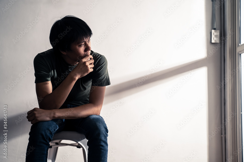 Asian male unemployed worker sitting on chair feeling stress and ...