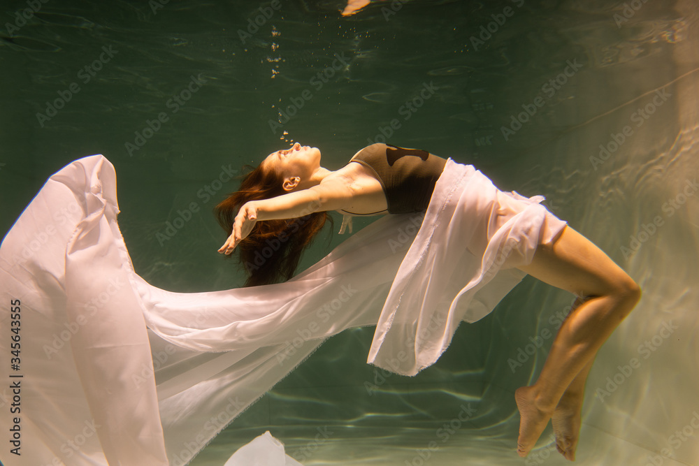 Beautiful Girl Swims Underwater With Long Hair Blue Or Gold Background Like Gold The