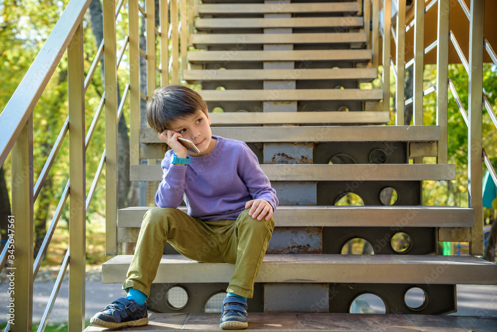 Closeup portrait, worried, sad young child, boy talking on phone to ...