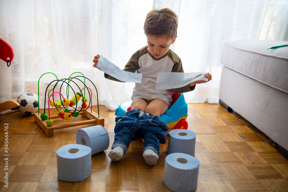 Toddler sitting on his potty as he starts his potty training. Learning ...
