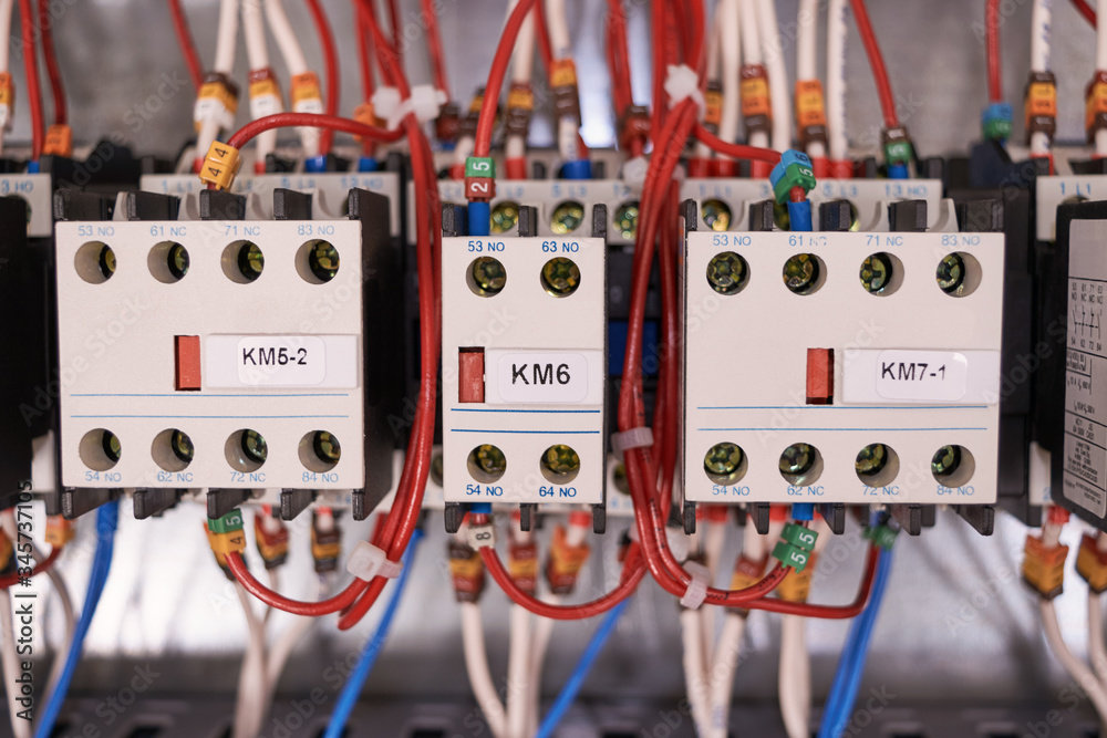 Three contactors or magnetic starters with front contacts are arranged ...